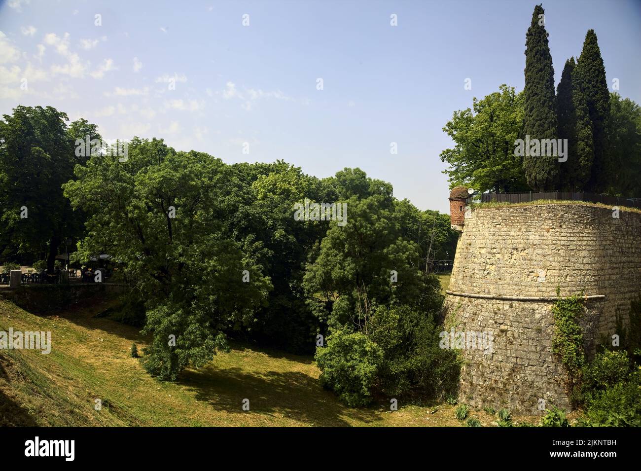 Fortification wall and moat with trees of a castle in a park on a sunny ...