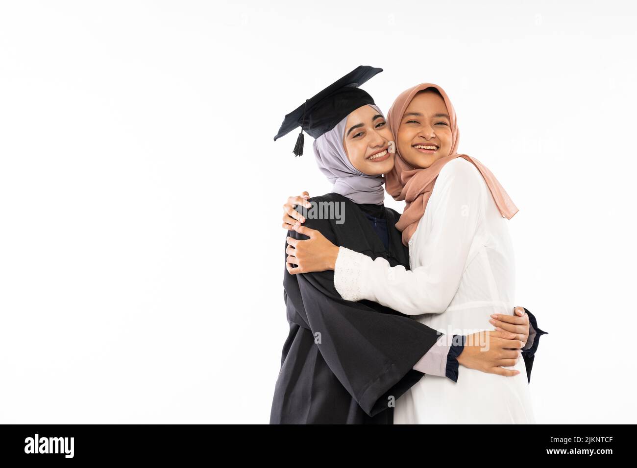 Asian female graduate student wearing toga hugging her sister Stock ...