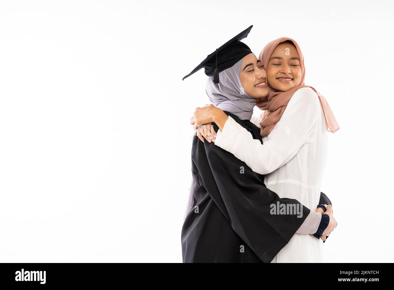 Happy asian female graduate student wearing toga hugging her mother ...