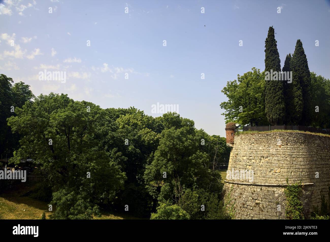 Fortification wall and moat with trees of a castle in a park on a sunny ...