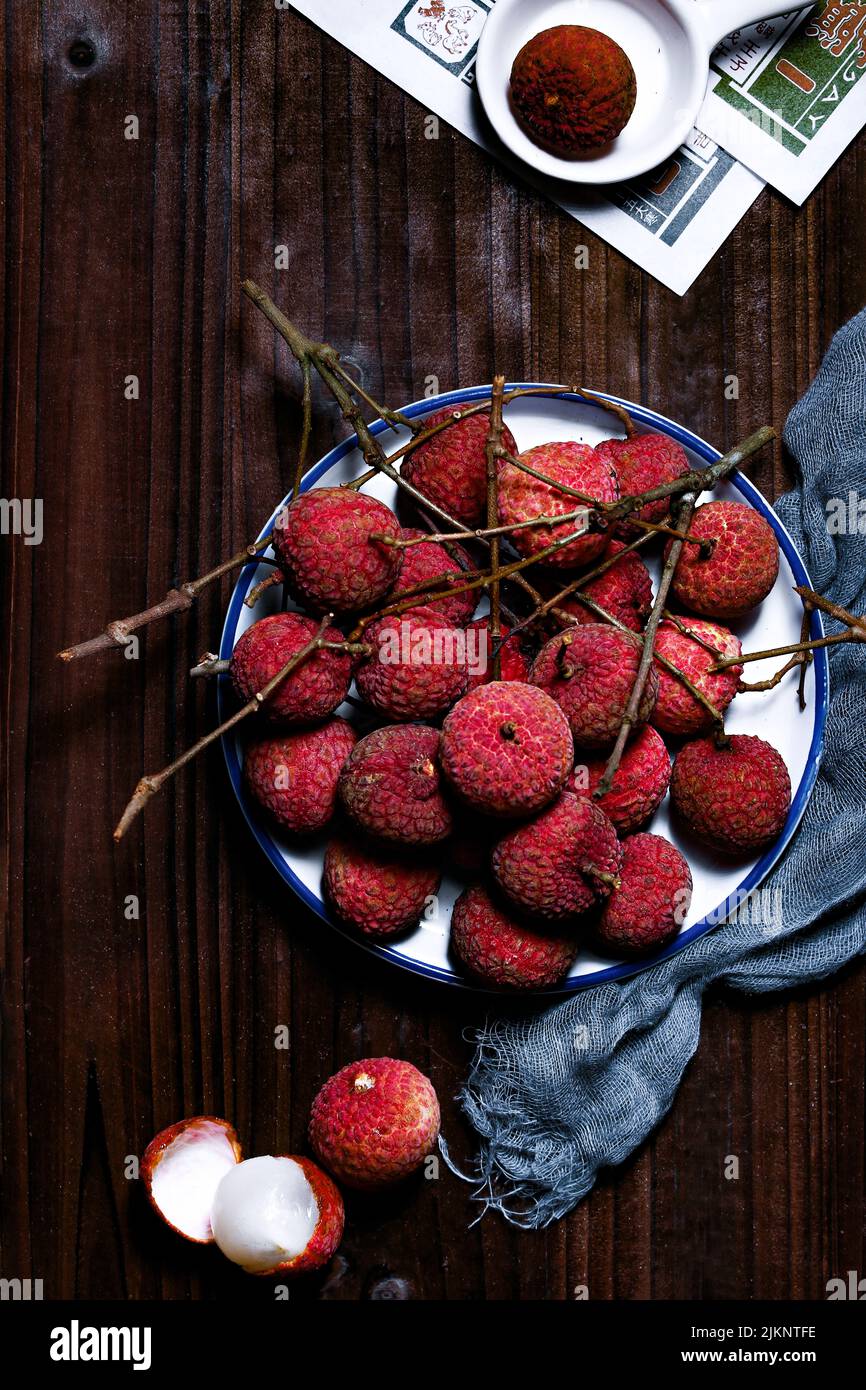 A vertical closeup of the Lychee fruits on the wooden table. Top view ...