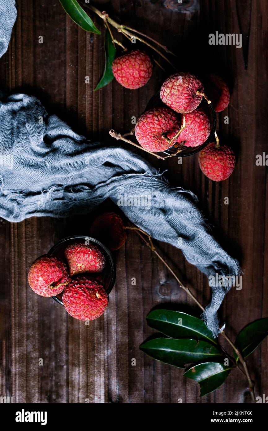 A vertical closeup of the Lychee fruits on the wooden table. Top view ...