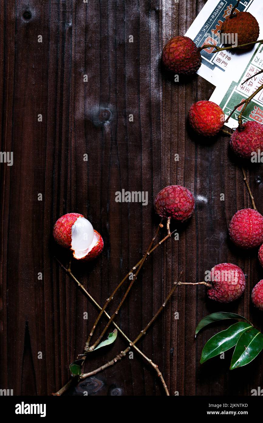 A vertical closeup of the Lychee fruits on the wooden table. Top view ...