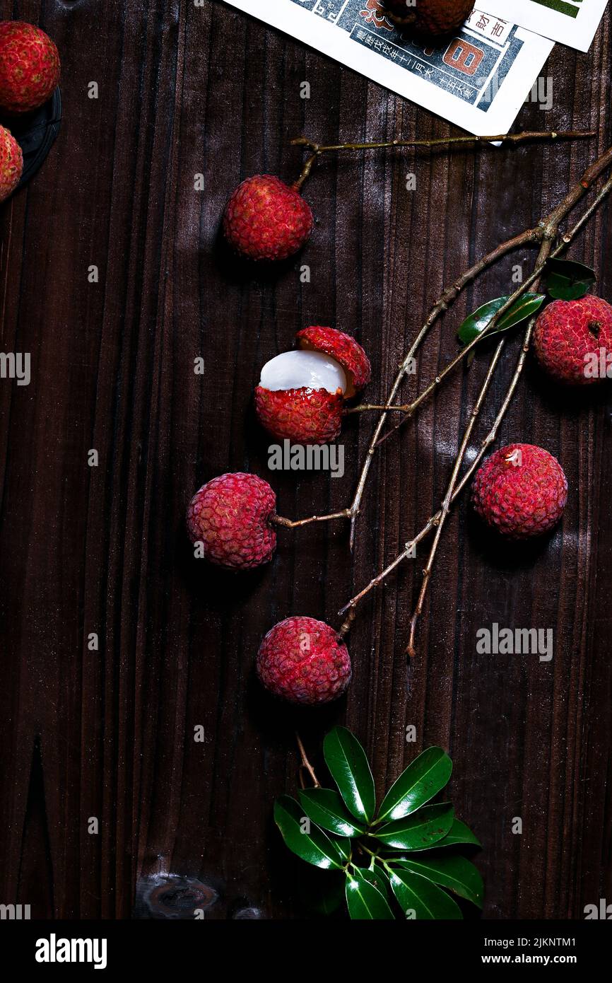 A vertical closeup of the Lychee fruits on the wooden table. Top view ...