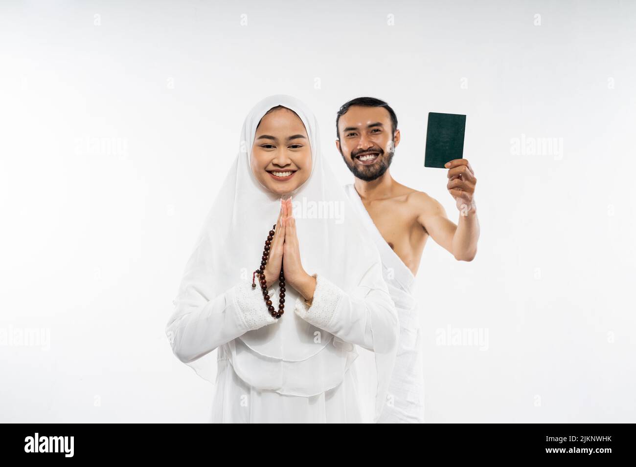 husband and wife wearing ihram clothes holding a passport Stock Photo ...