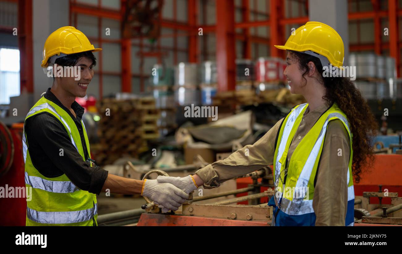 Foreman and Woman in safety suit shake hands and conclude a job for ...