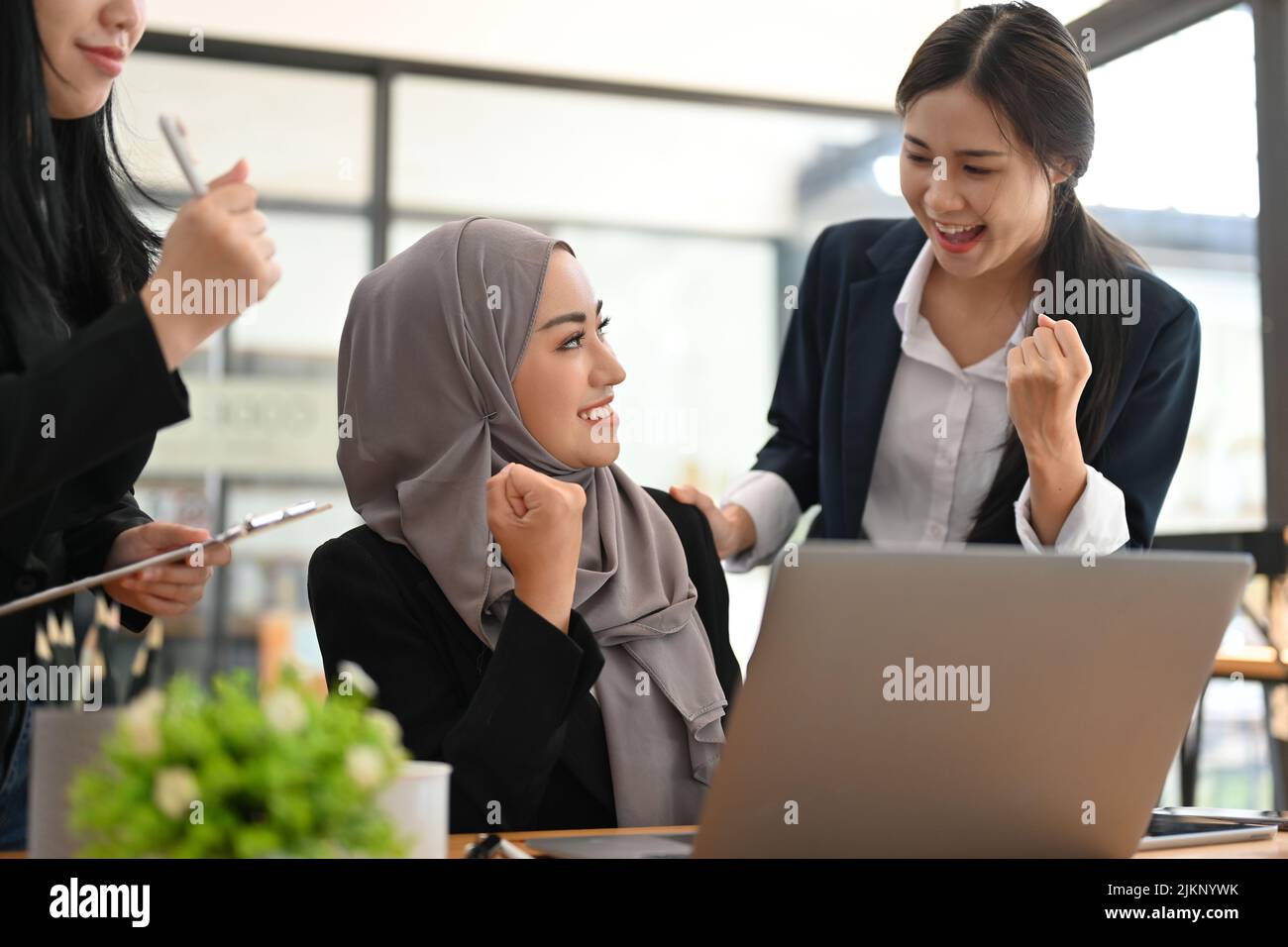 Happy young Asian businesswomen working together, getting a work ...