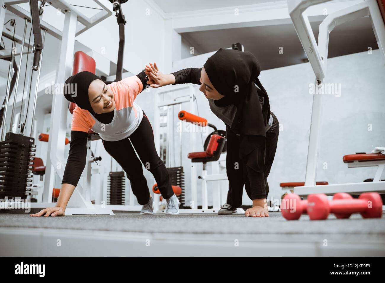 muslim woman with hijab push up and high five workout together Stock ...
