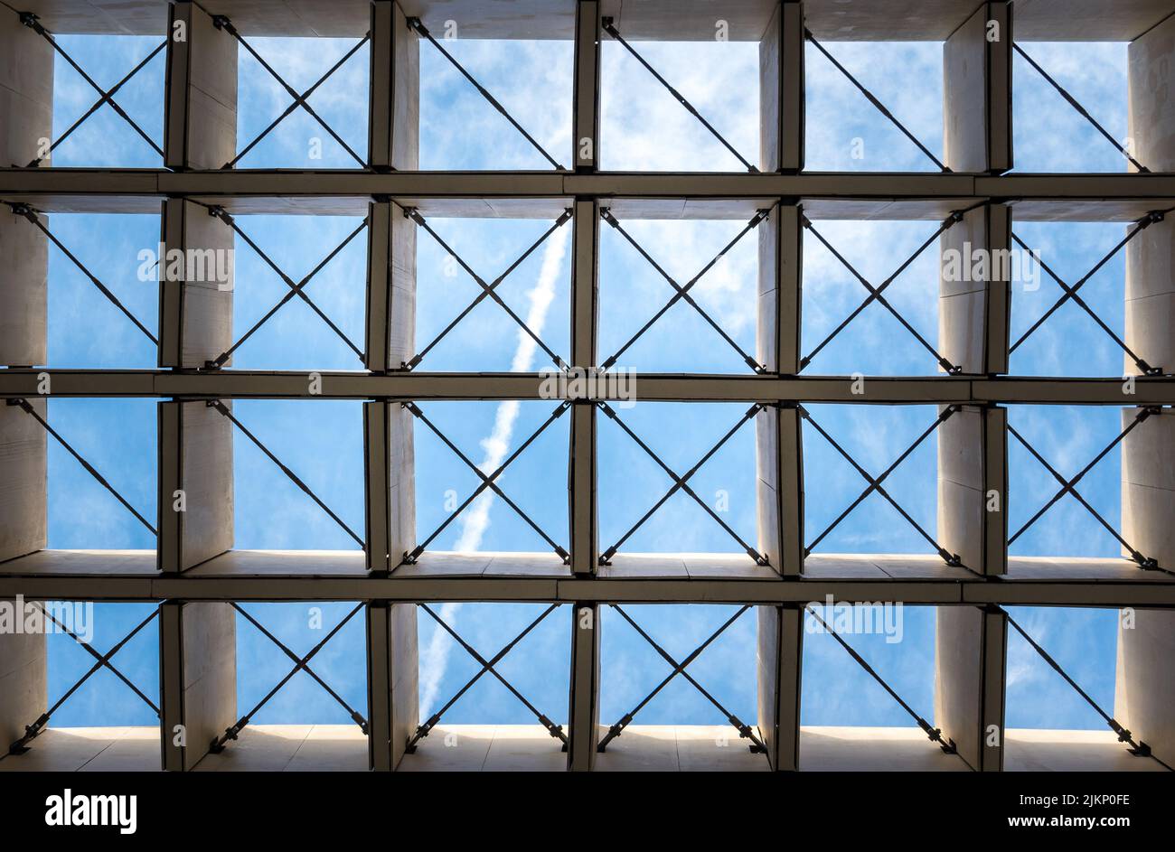 A low-angle shot of a window ceiling with the view of the blue sky with ...