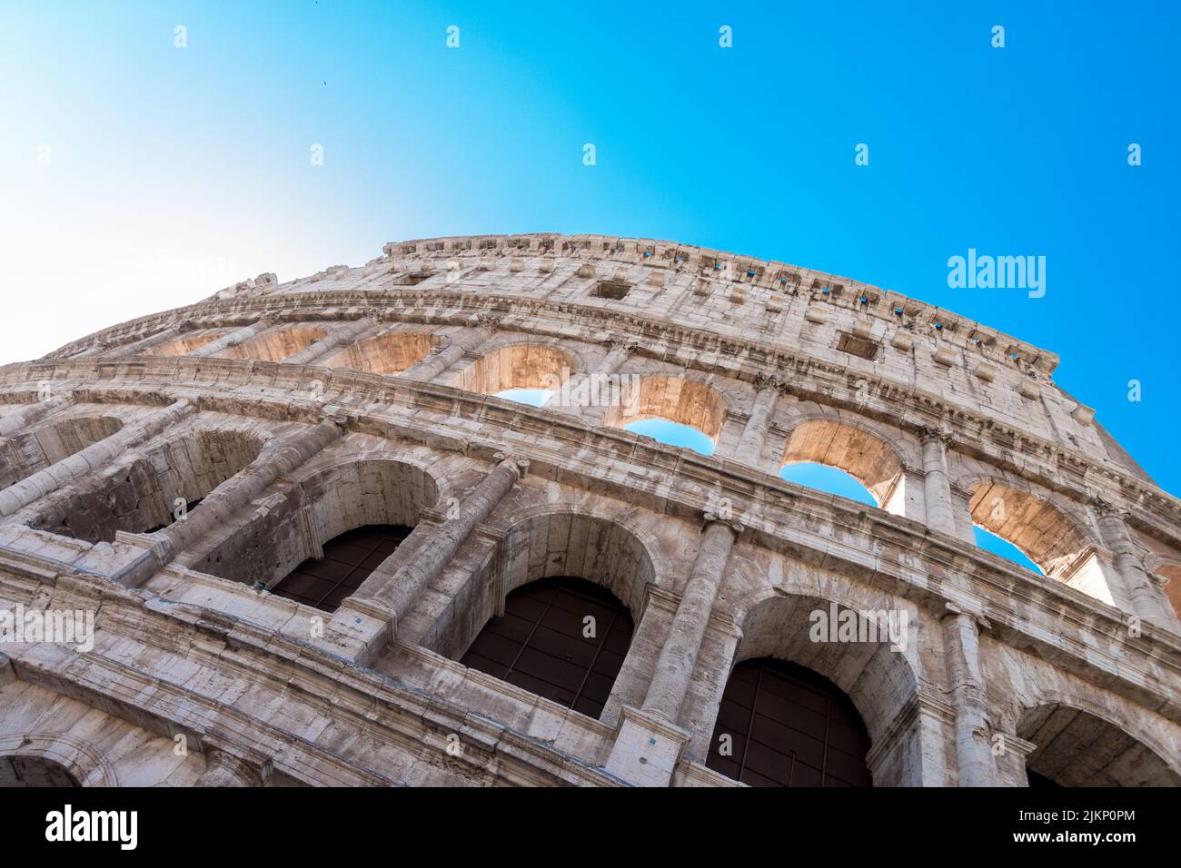 A low angle shot of the Colosseum on the blue sky background, Rome ...