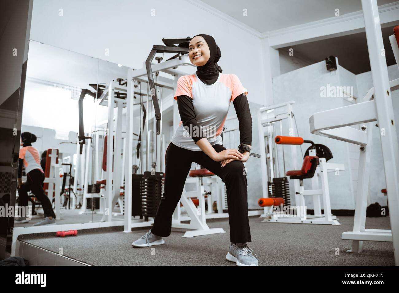 sports girl smiles stretching her body in the gym, lifestyle, healthy ...