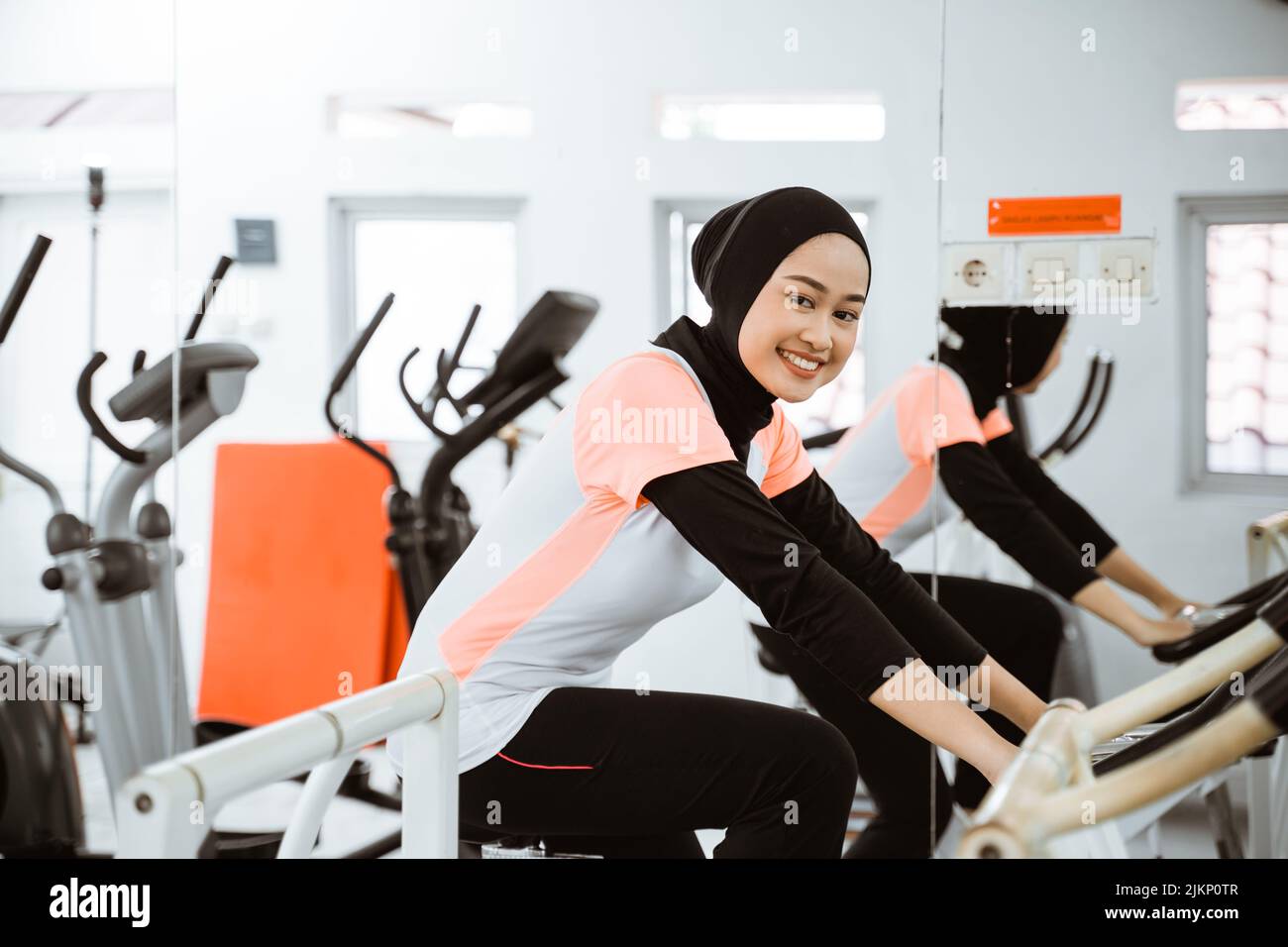 muslim woman exercising with static bike at the gym Stock Photo - Alamy