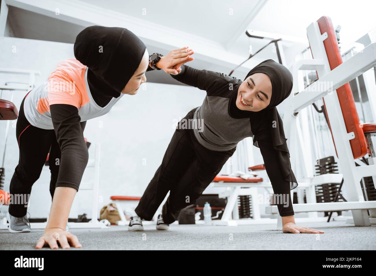 muslim woman with hijab push up and high five workout together Stock ...