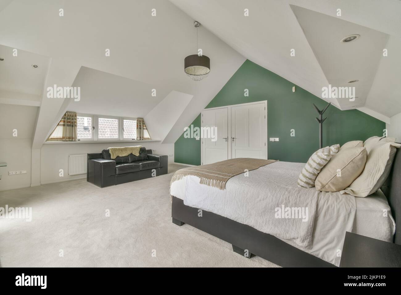 Comfortable bed placed near green wall in modern minimalist style ...