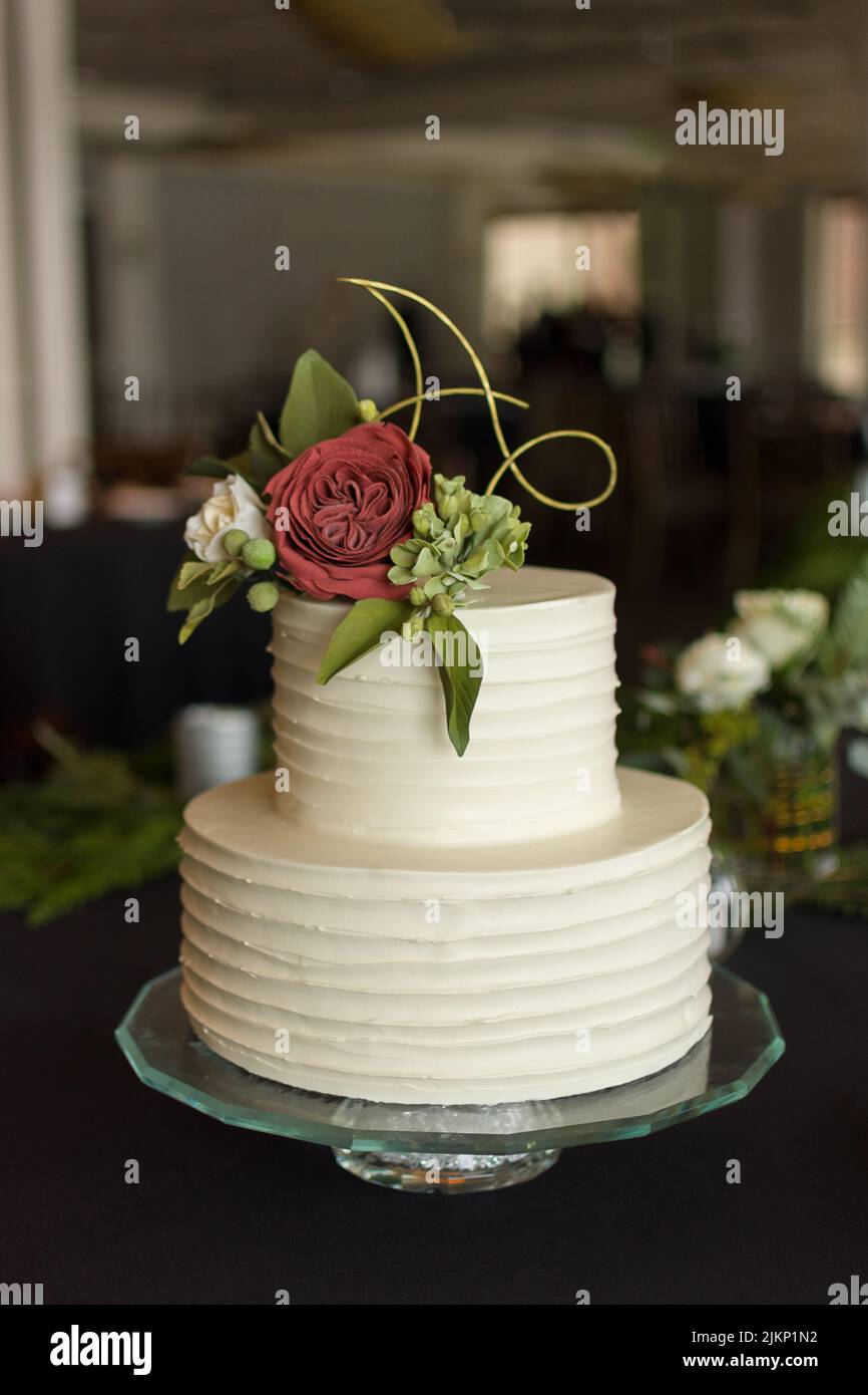 A vertical closeup shot of a 2 tier ruffle wedding cake with an edible ...