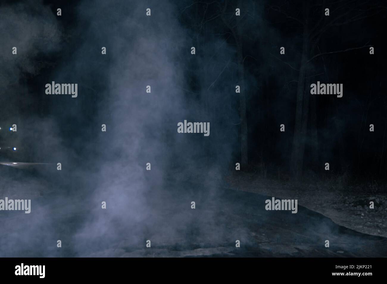 A night view of a smoke over a road in a forested area Stock Photo - Alamy