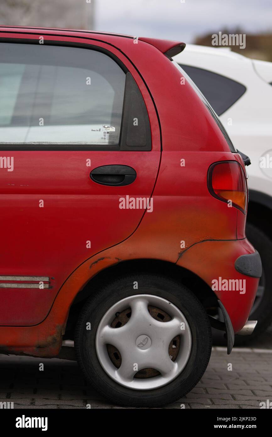 A vertical shot of the wheel and the back part of a red car Stock Photo ...