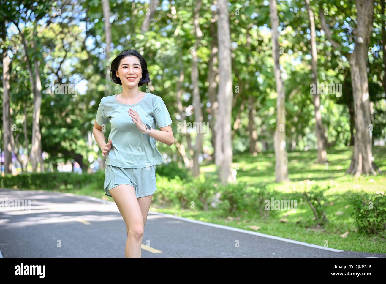 Active and fit millennial Asian female running and jogging in the ...