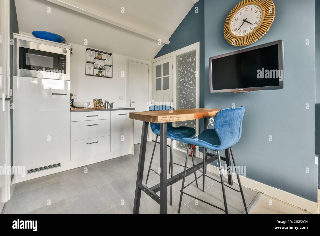Spacious attic room of apartment with dining table and chairs near open ...