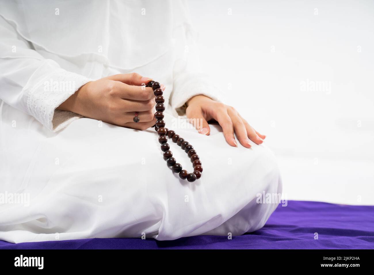 Woman's hand praying with prayer rug and prayer beads Stock Photo - Alamy