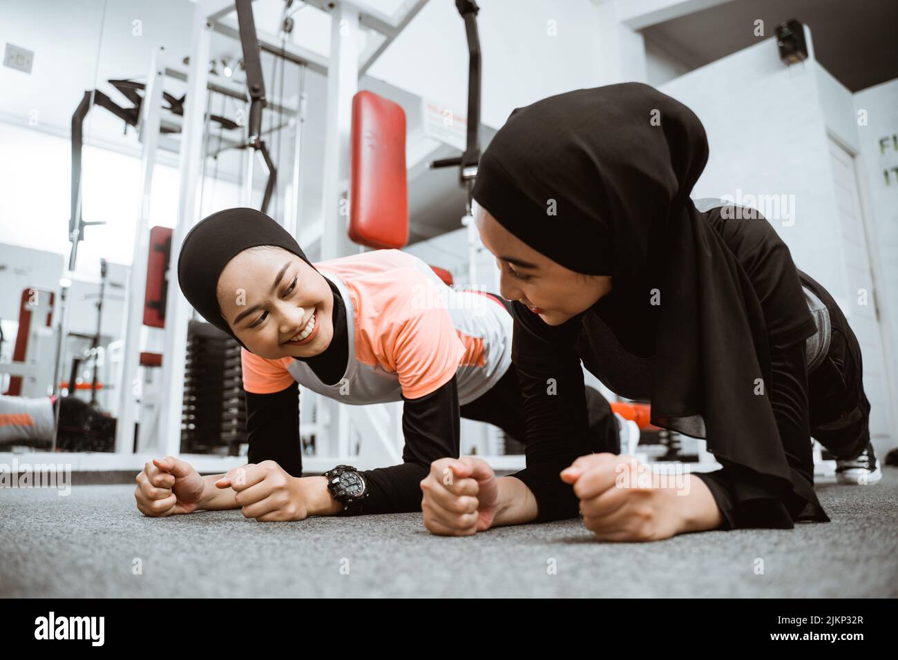 asian muslim woman doing plank push up with partner Stock Photo - Alamy