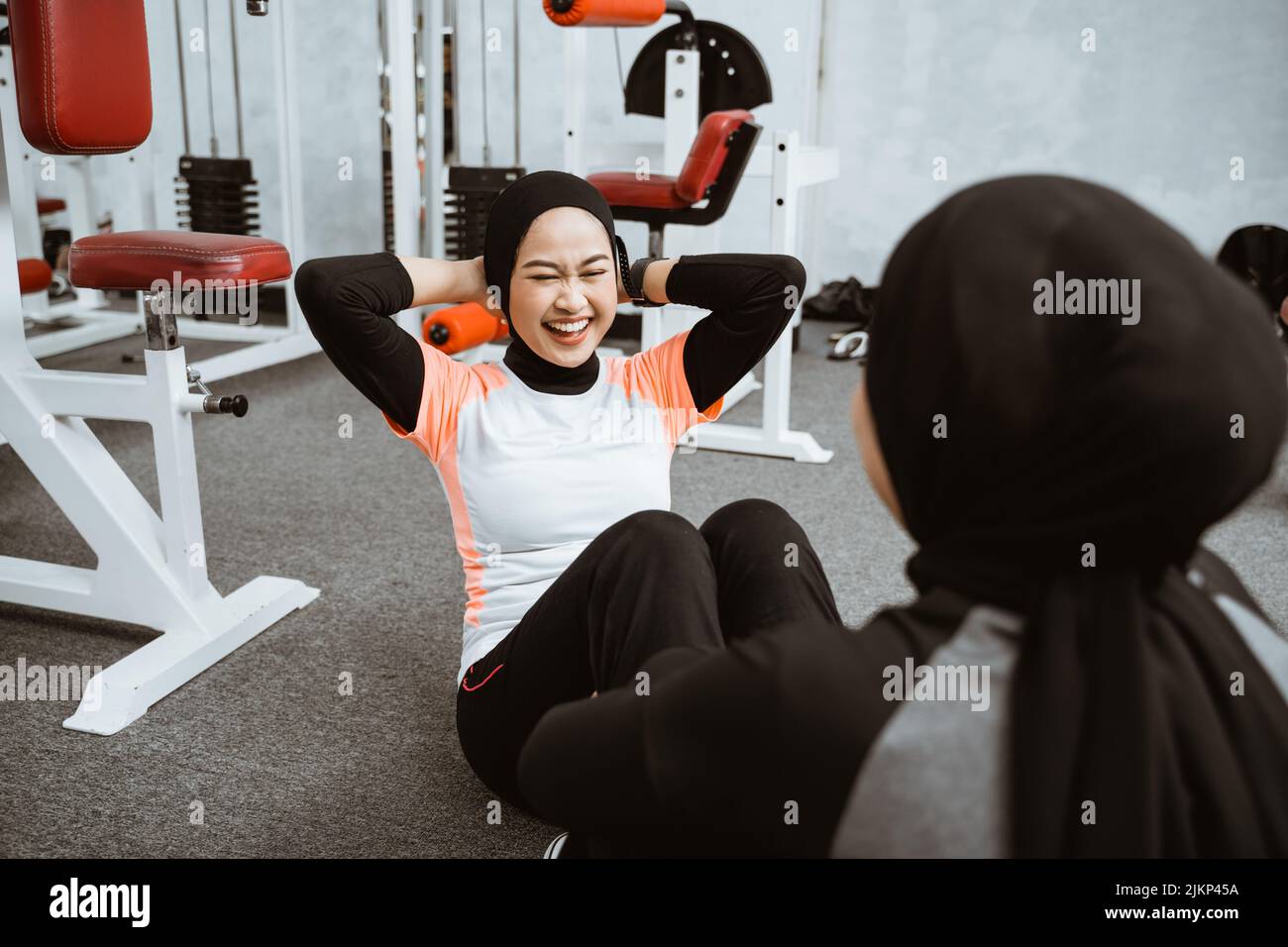 muslim woman sitting up exercise with partner at the gym Stock Photo ...