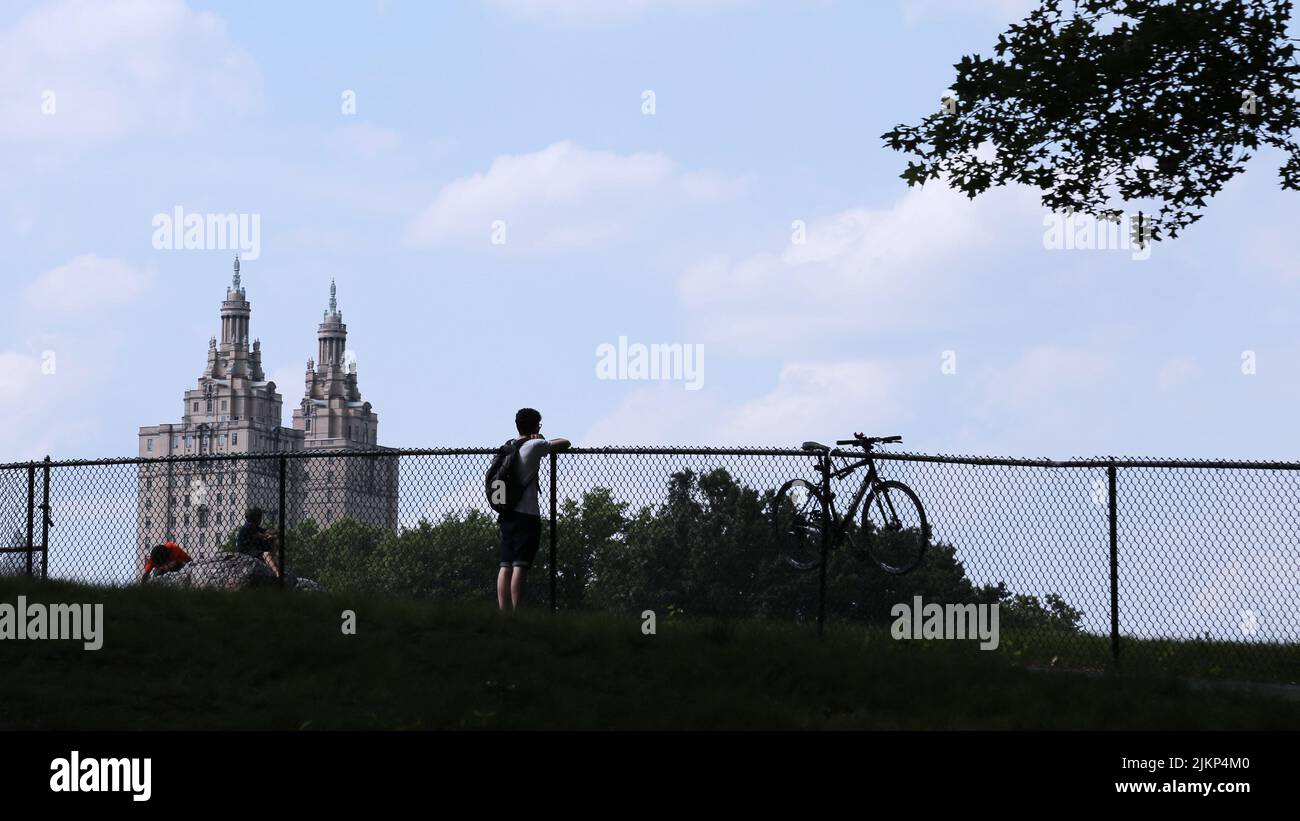 Some boys with bikes looking over a wire fence with a white castle in ...