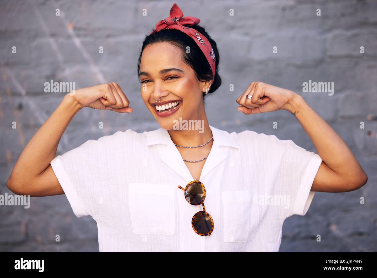 Pretty but strong. an attractive young woman standing alone against a ...
