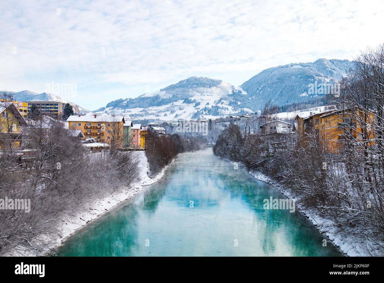 A reflective river with coastline buildings on the background of ...