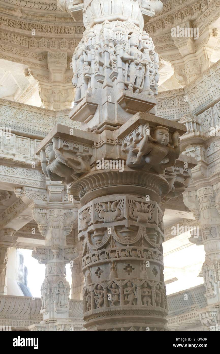 A vertical shot of an intricate sculpted column in the Ranakpur Jain ...