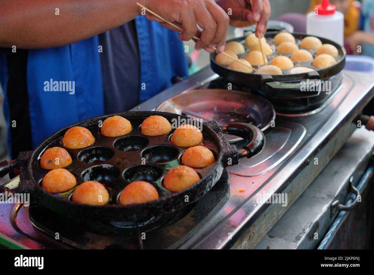 A person's hands flipping traditional Burmese Mont lin maya on the ...