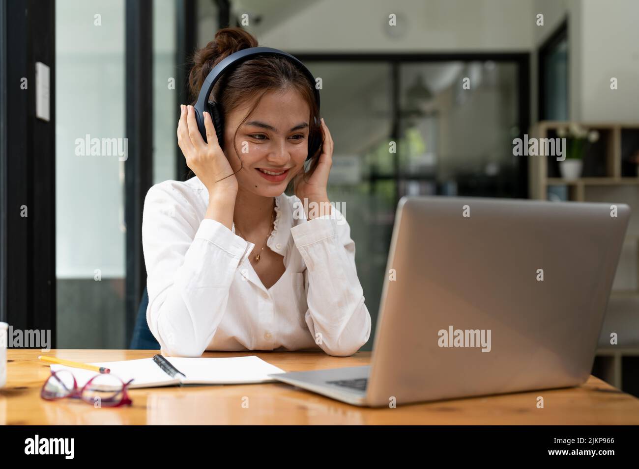 Online education, e-learning. young woman studying remotely, using a laptop, listening to online ...