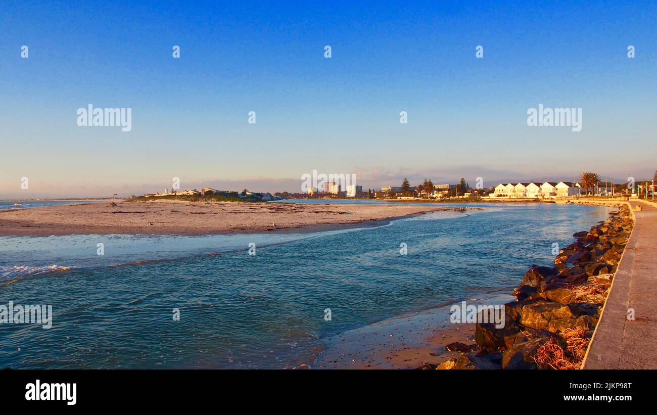 A scenic view of a blue ocean next to the road in blue sky background ...