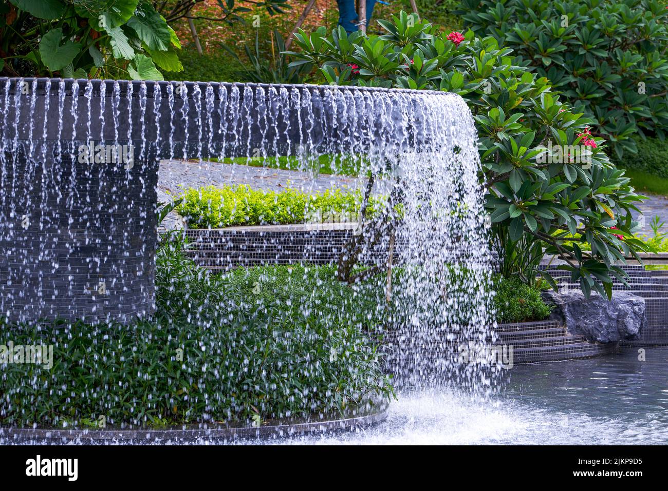 Landscape of man-made flowing water fountain in the park Stock Photo ...