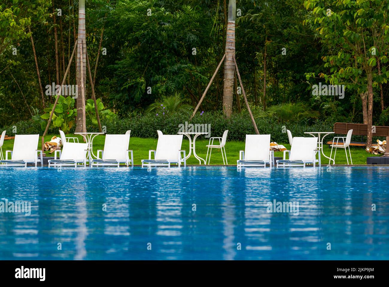 Infinity pool and lounge chairs in a luxury hotel Stock Photo - Alamy