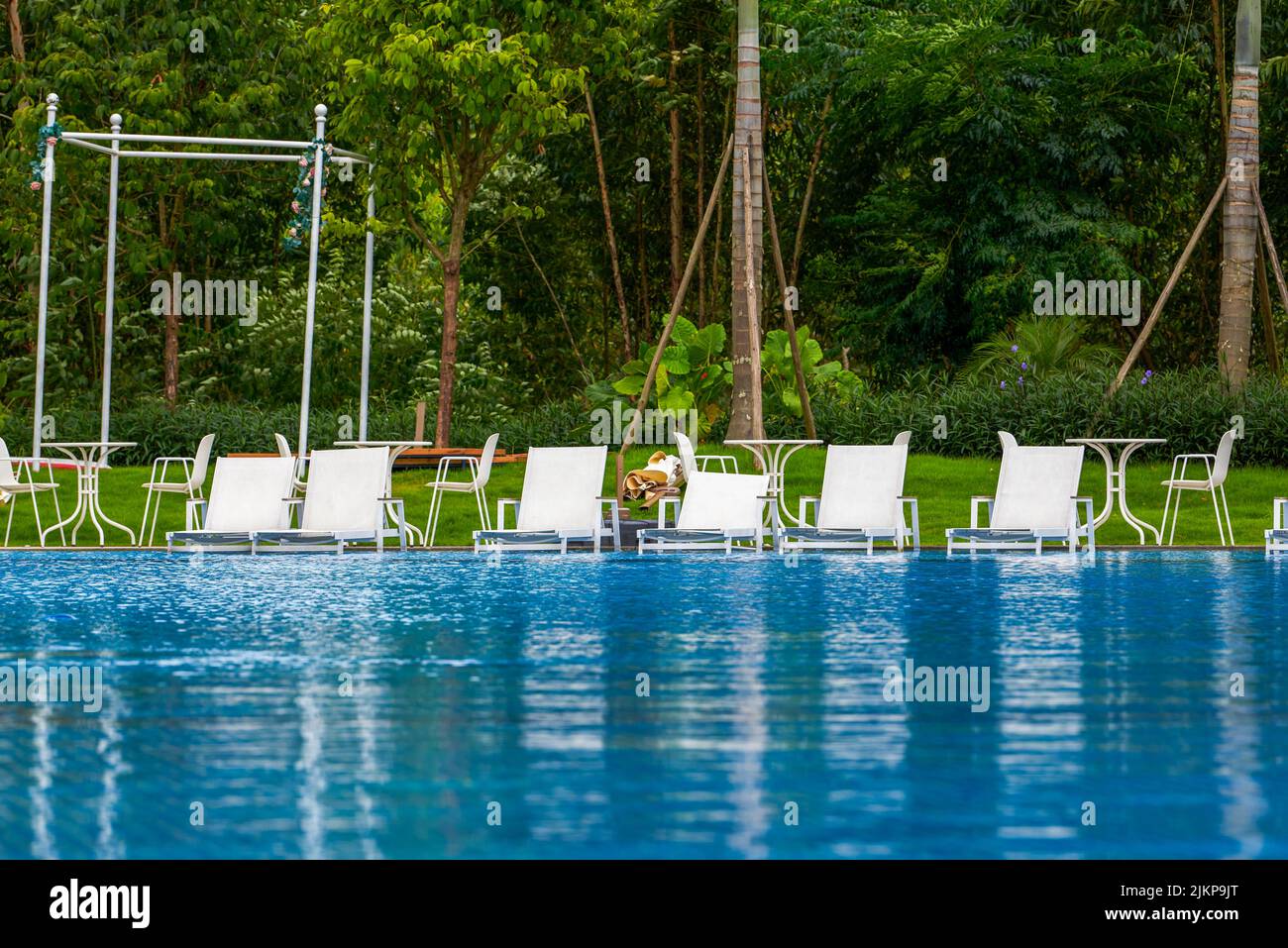 Infinity pool and lounge chairs in a luxury hotel Stock Photo - Alamy