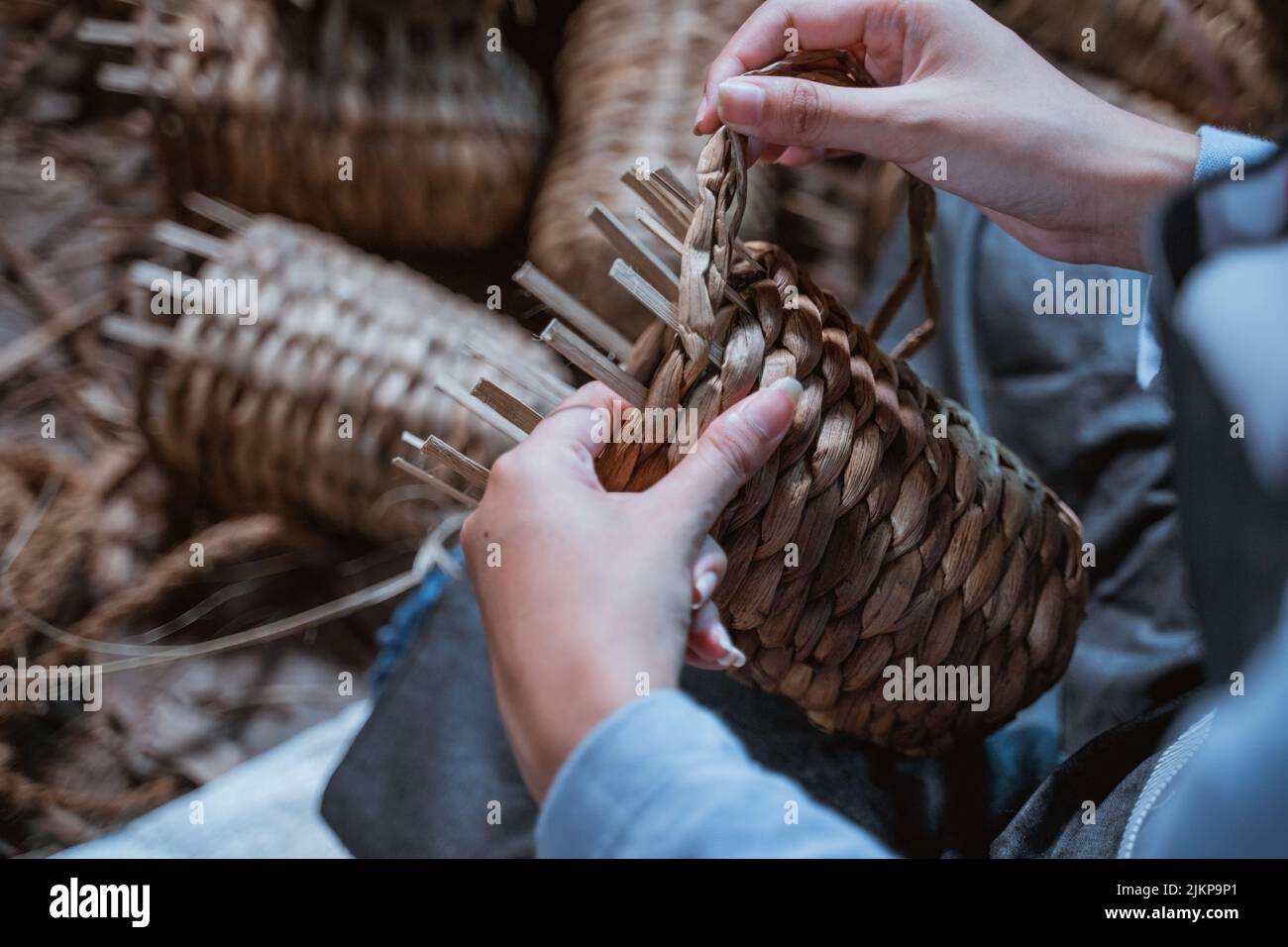 close up of craftswoman hands weaving water hyachinths making crafts ...