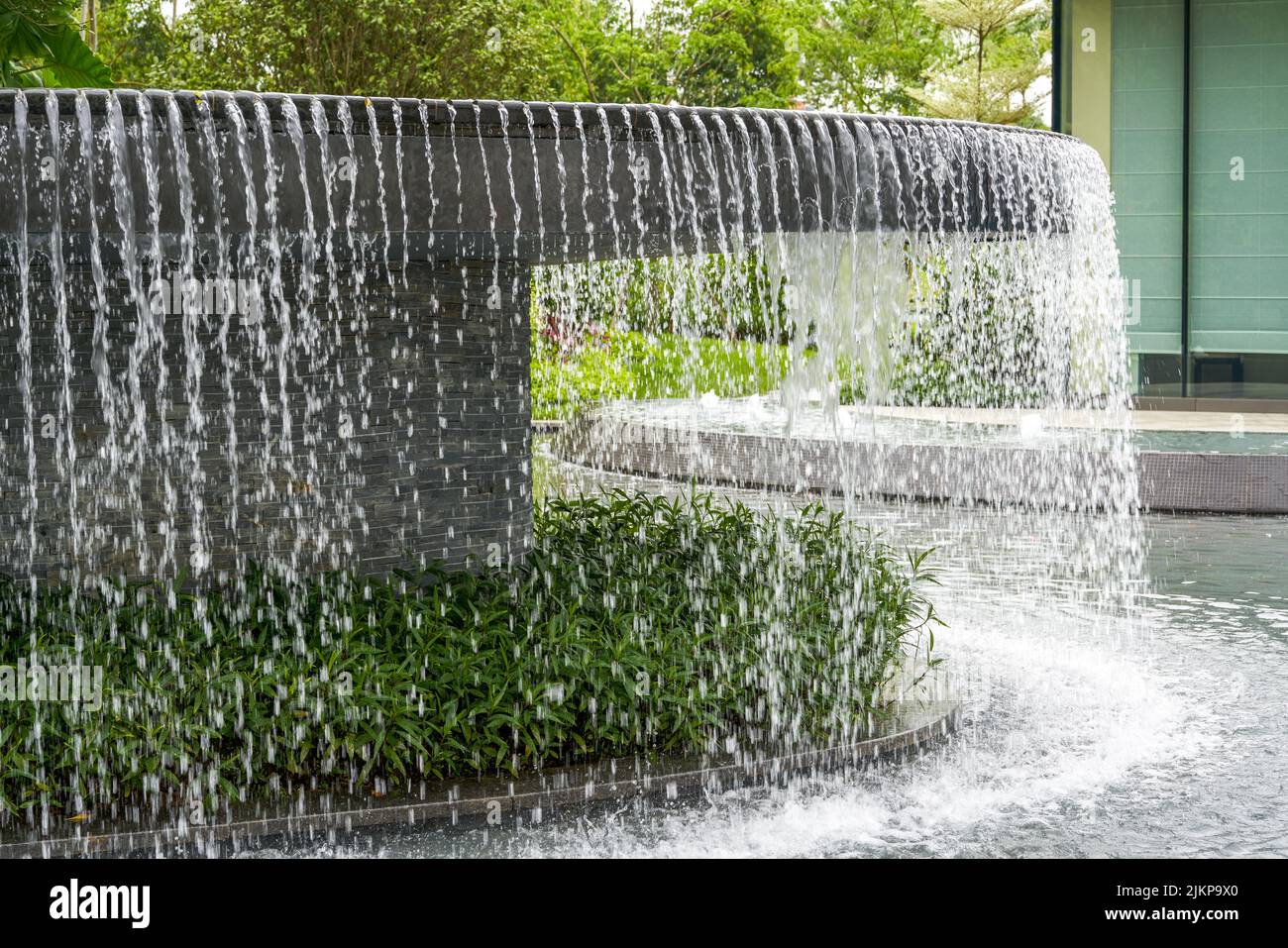 Landscape of man-made flowing water fountain in the park Stock Photo ...