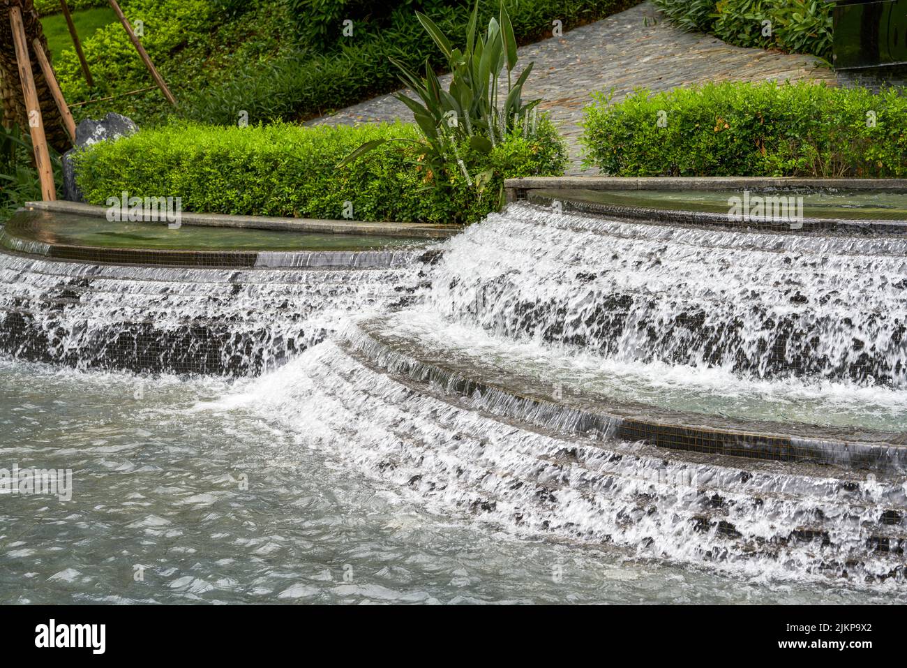 Landscape of man-made flowing water fountain in the park Stock Photo ...