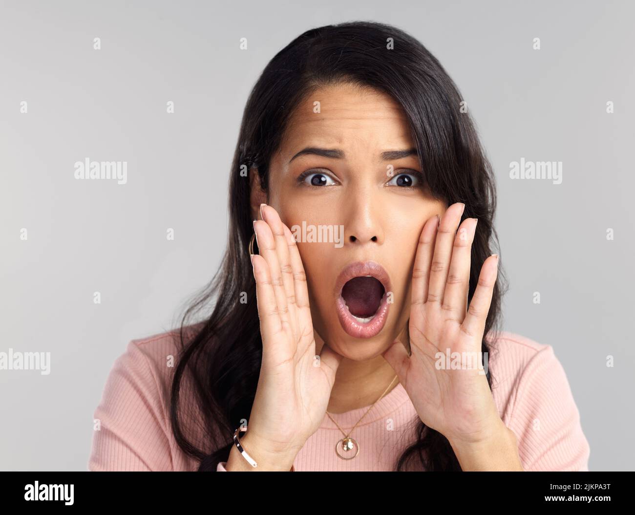 Everyone should know. a beautiful young woman shouting against a grey ...