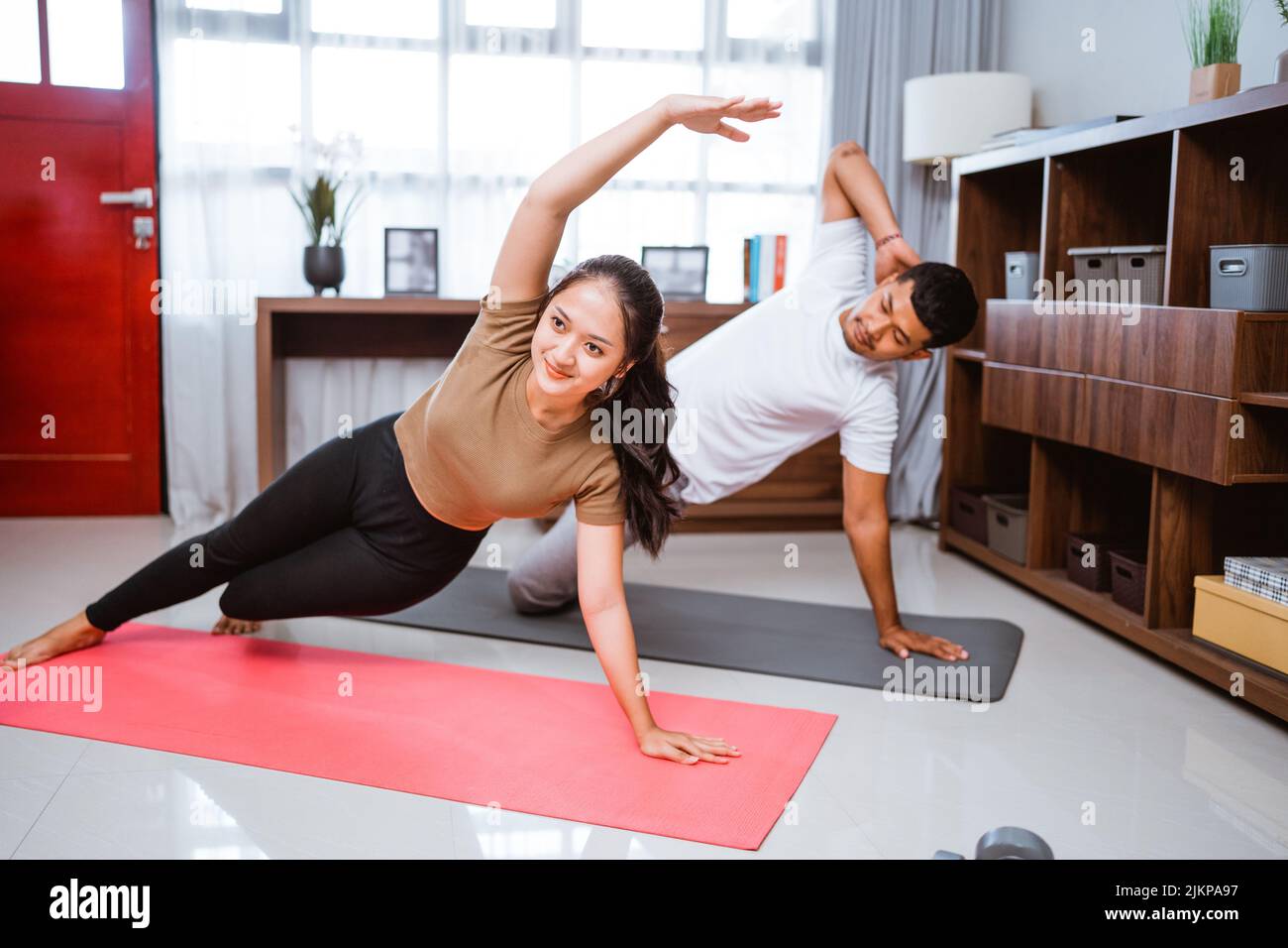 Asian fitness couple, man and woman exercising together at home Stock ...