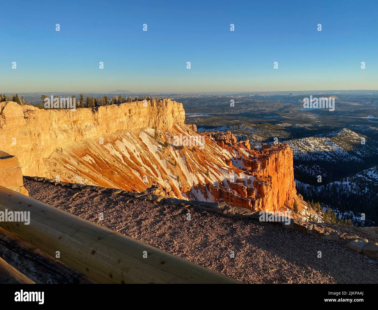 A cliff and valley landscape transitioning from winter against a clear ...