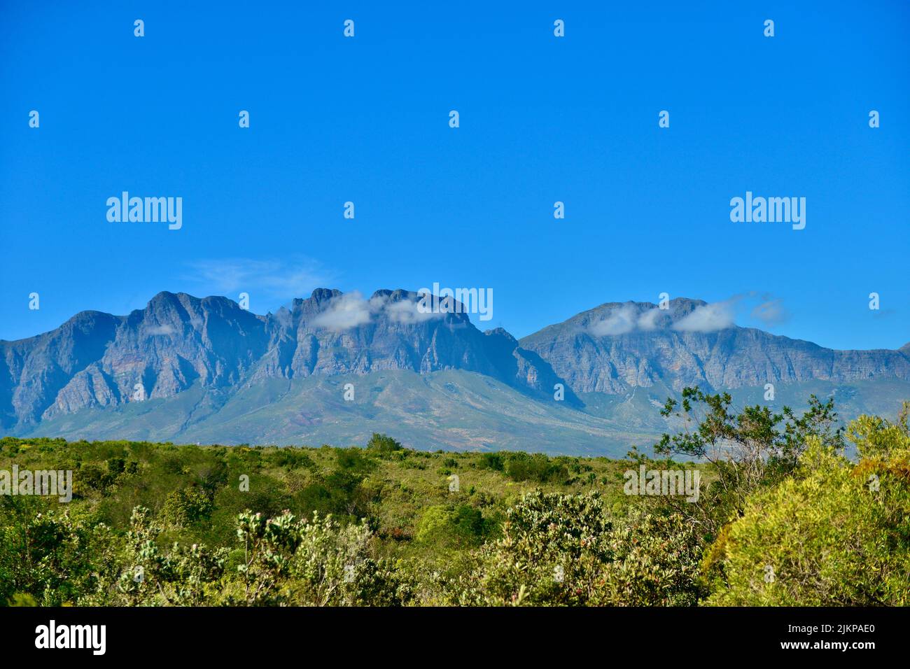 A scenic view of rocky mountains in a rural area in blue sky background ...