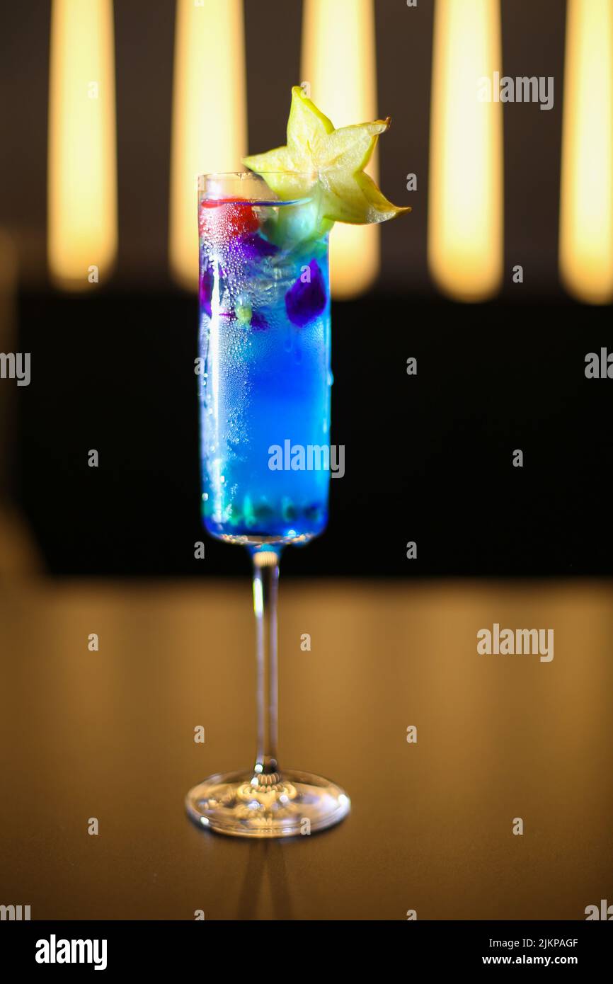 A big glass cup of fancy and tasty fruit cocktail on a burred ...