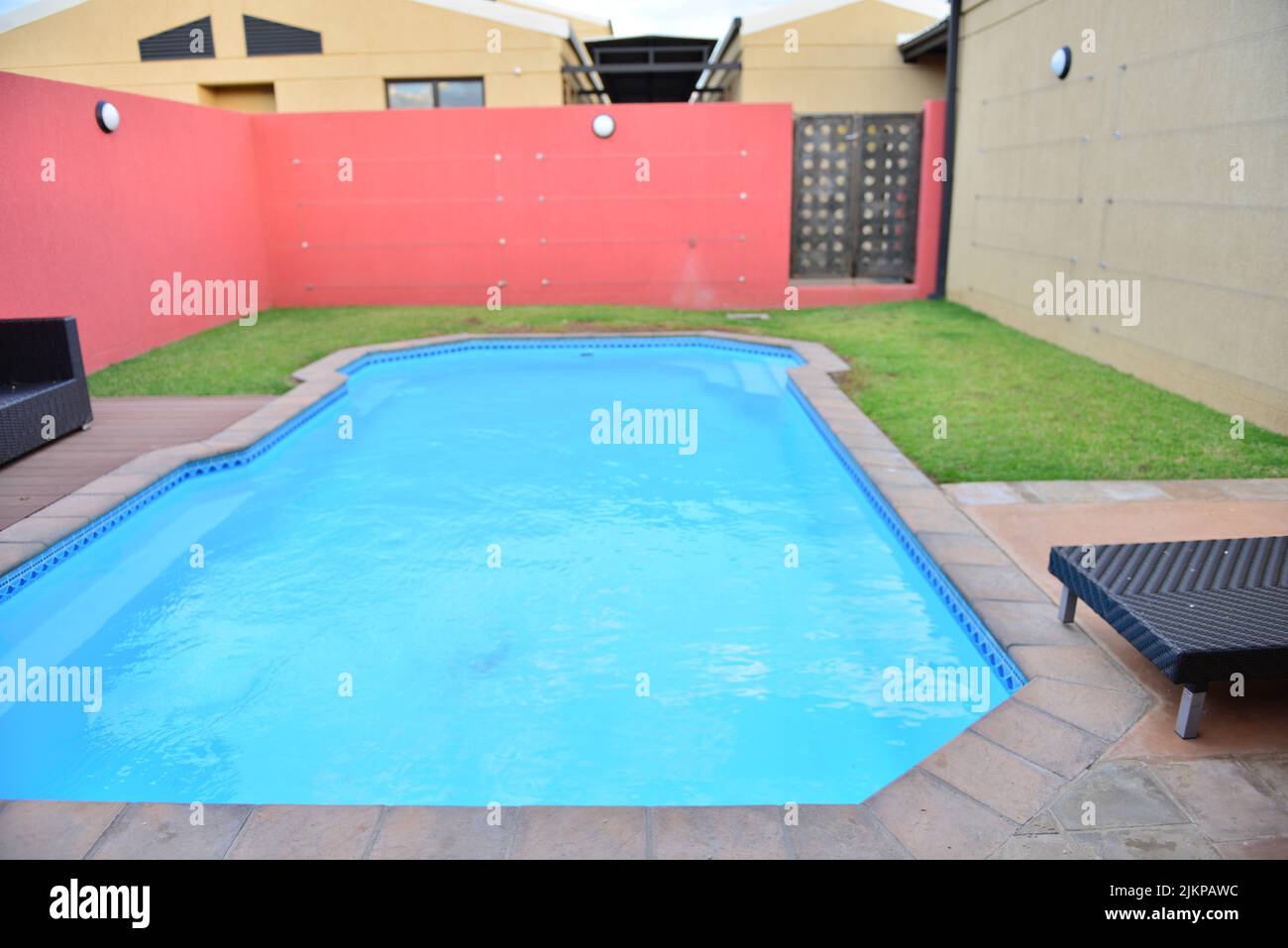 A beautiful view of a pink house with an outdoor small swimming pool ...