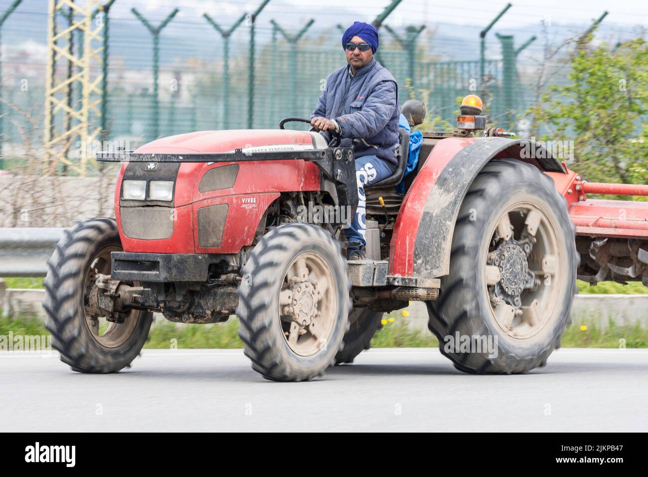 Little and modern red tractor in the city. Massey Ferguson model Stock ...