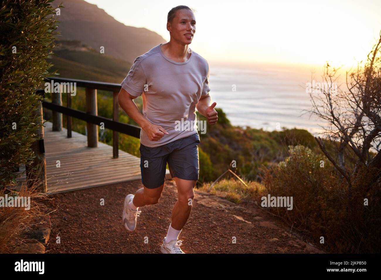 Keep your heart rate up. a young man running alone outside Stock Photo ...