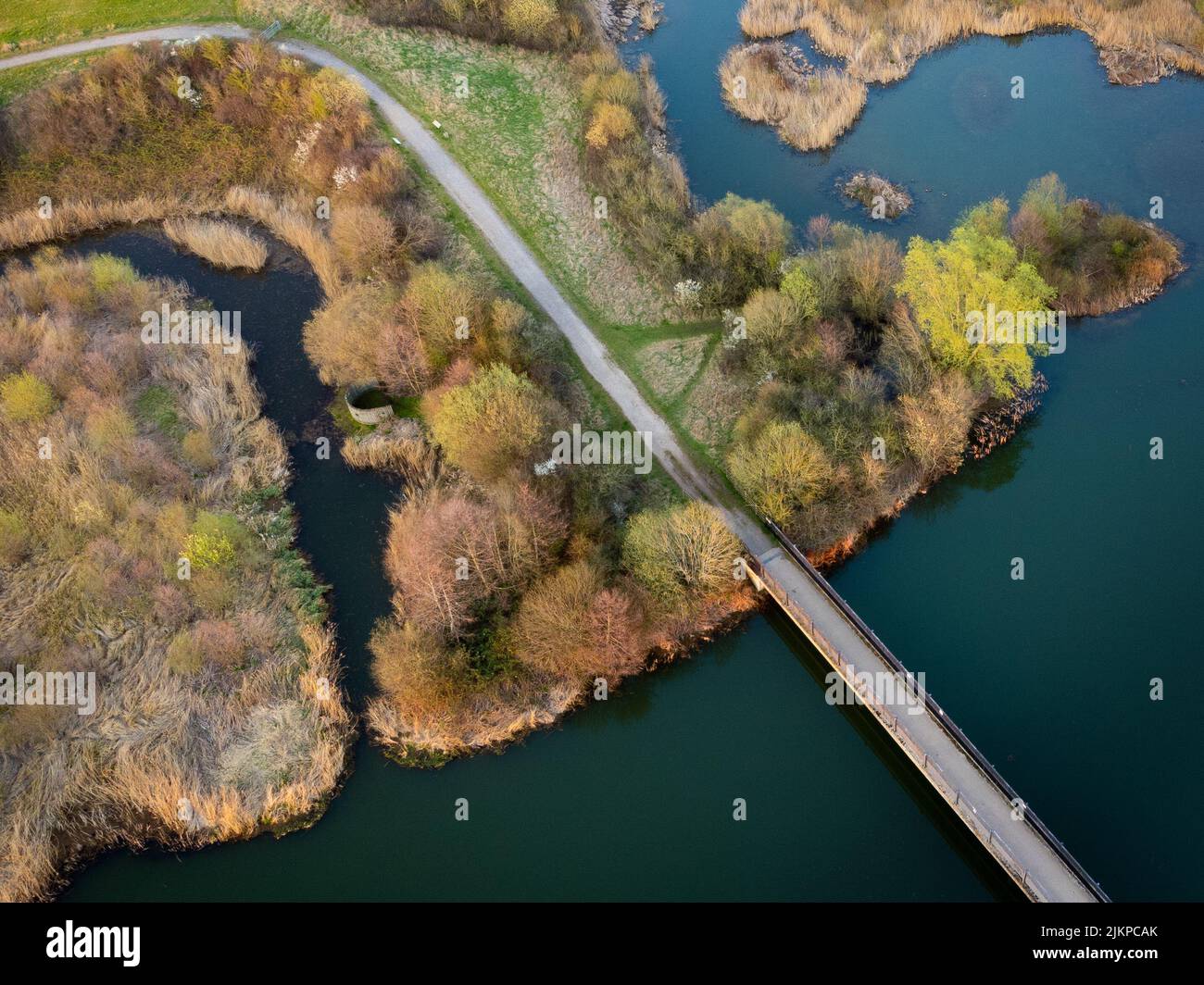 An aerial view of a bridge over a lake connected to an island full of ...