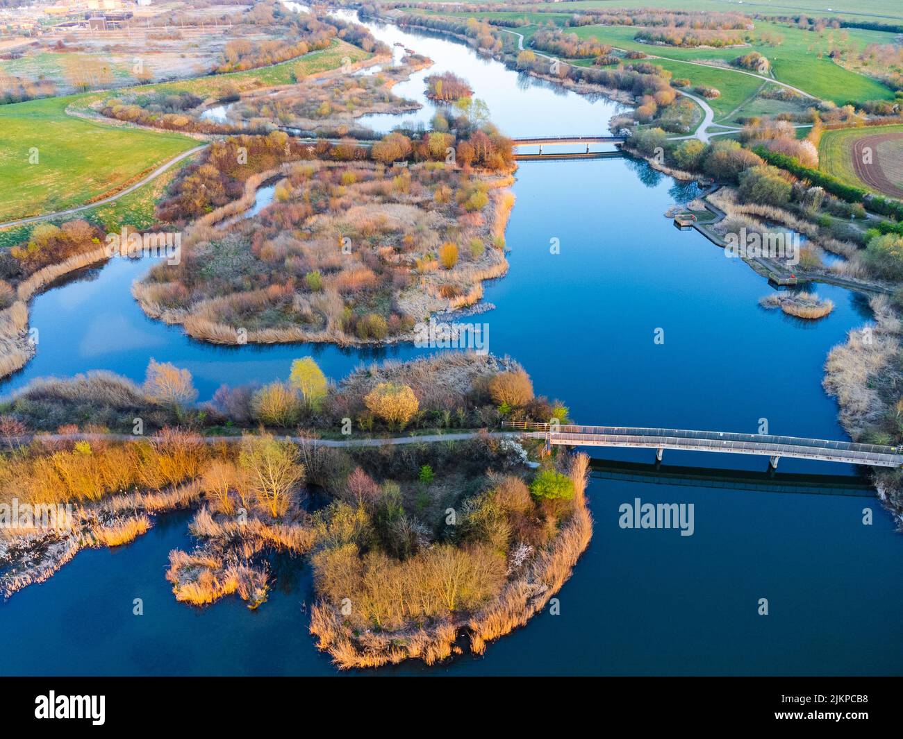 An aerial view of a bridge over a lake connected to an island full of ...