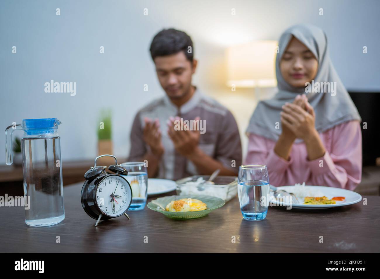 muslim couple praying for their food during morning breakfast Stock ...